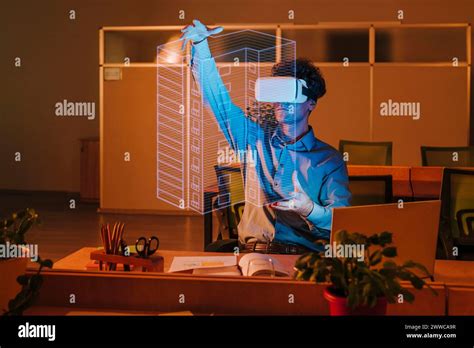 Architect Wearing Virtual Reality Simulator And Examining Blueprint
