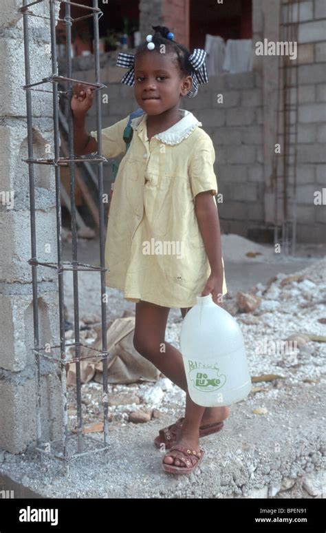 HAITI GIRL FETCHING WATER IN THE SHANTY TOWNS OF PORT AU PRINCE Stock