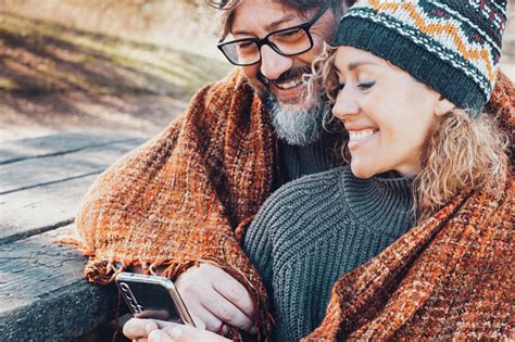 야외 여가 활동과 공원에서 낭만적인 하루를 함께 보내는 행복한 커플 사랑과 관계 공유 기술 셀룰러 남자와 여자가 야외에서 채팅하고 메시지를 주고받는다 2명에 대한 스톡 사진