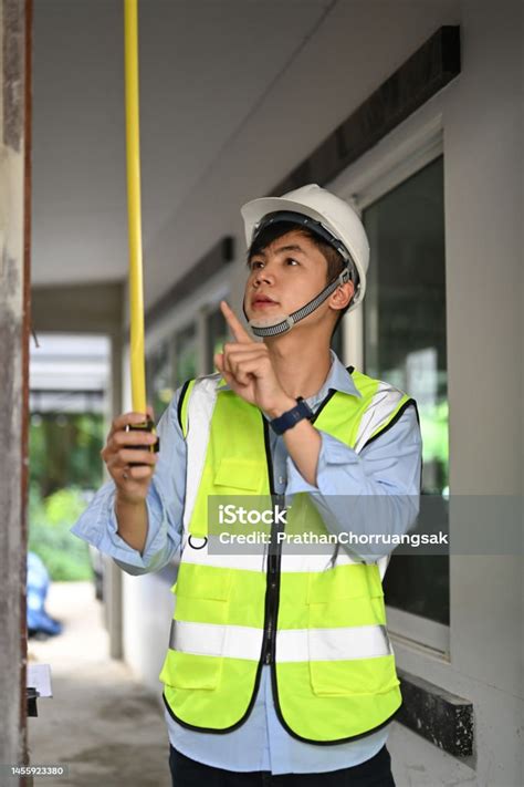 안전 헬멧과 조끼를 입은 엔지니어들이 건물 건설 현장을 검사합니다 산업 엔지니어 건설 개념 30 34세에 대한 스톡 사진 및