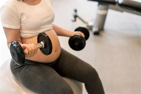 요가룸의 피트니스 센터에서 활동적인 임산부 운동을 합니다 임신 한 배에 아기를 들고 젊은 기대 어머니 출산 전 관리 및 여성 임신 개념 건강관리와 의술에 대한 스톡 사진 및