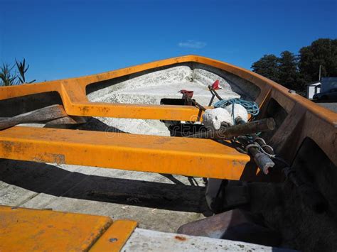 Small Dingy Or Tinny Moored At The Beach At Dusk With Waves Lapping At