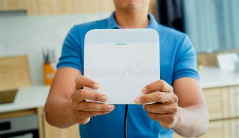 A Technician Installs A Main Unit Security System In A Modern Apartment