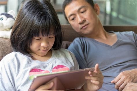 아버지와 딸 개념입니다 아빠 컴퓨터 노트북 손 키보드에서 작업 하는 동안 아시아 아이 소녀 태블릿 손을 사용 하 여 터치 스크린