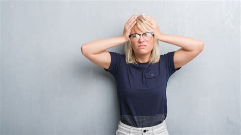 그런 지 회색 벽 때문에 두통 절망과 스트레스에서 고통 하는 안경 착용을 통해 성인 백인 여자 통증과 편두통 머리에 손입니다 T 셔츠에 대한 스톡 사진 및 기타 이미지