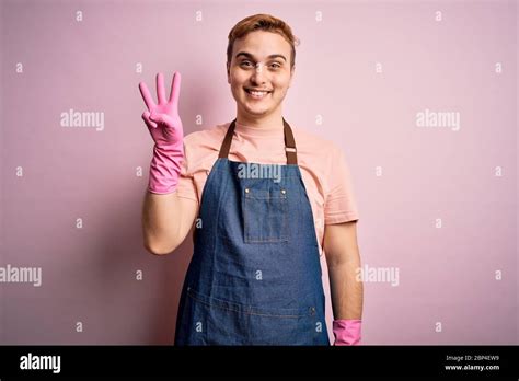 Young Handsome Redhead Cleaner Man Doing Housework Wearing Apron And