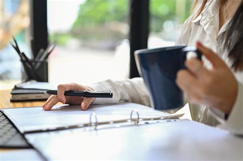 커피 컵을 들고 종이 문서를 읽고 책상에서 통계 재무 결과를 분석하는 여성 사업가 20 24세에 대한 스톡 사진 및 기타 이미지 20 24세 25 29세 개발