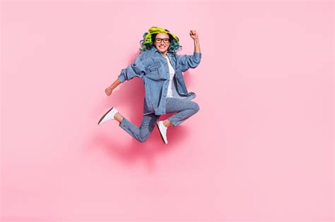 핑크 파스텔 컬러 배경에서 고립된 달리기 를 뛰어 다니는 매력적인 쾌활한 동기를 부여한 물결 모양의 소녀의 전체 길이 바디