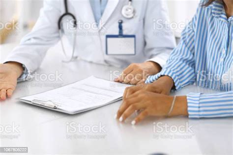 의사와 얘기 하 고 책상에 앉아 있는 동안 건강 치료에 대해 환자 의학 및 건강 관리 개념입니다 가리키기에 대한 스톡 사진 및