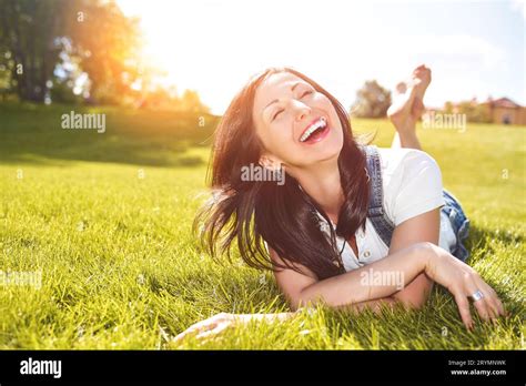 Positive Emotion Adult Woman Relaxed Lying On Green Grass In An
