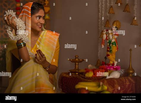 Woman Worshipping Lord Krishna On The Occasion Of Janmashtami Stock