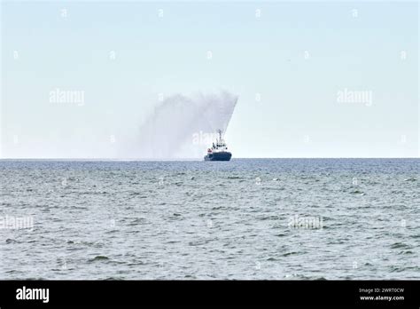 Fireboat Ship Sails On Open Sea Directing Jets Of Water To Sides