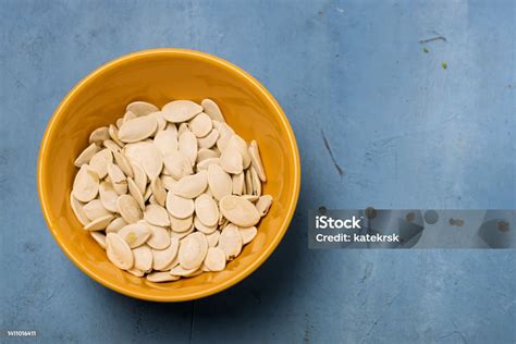 파란색 배경 복사 공간에 소금에 절인 호박 씨앗이있는 노란색 그릇 10월에 대한 스톡 사진 및 기타 이미지 10월 가을 개체 그룹 Istock