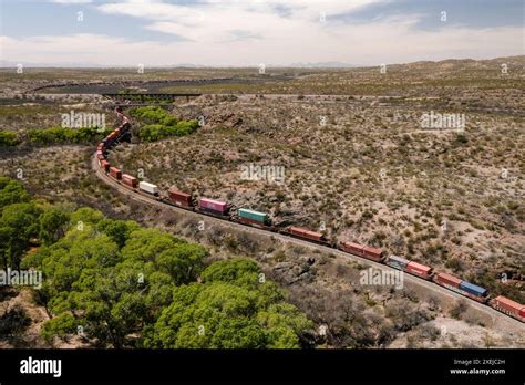 Aerial View Of Long Container Stack Trains Winding Around Curves Stock