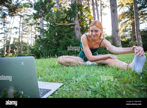 An Athlete Performs Stretching Exercises Following Online Lessons With