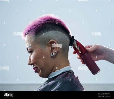 The Hairdresser Shaves The Back Of The Head Of A Female Client Rear