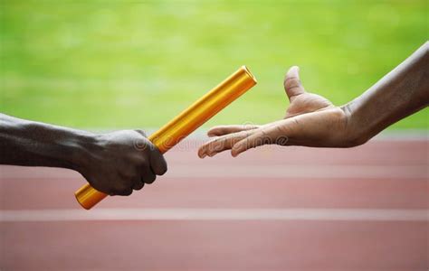 Two Men Passing Golden Baton In Stadium Conceptual Image Shot Stock