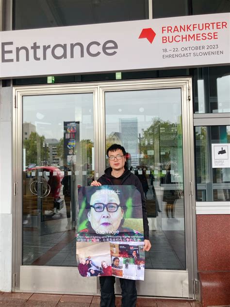 旅欧作家王庆民在法兰克福书展上展示海报，呼吁释放许志永等政治犯、关注气候危机、 山河四省”平权、铭记南京大屠杀和河南血祸等历史，以及寄愿巴以和平、俄乌和平 独立中文笔会