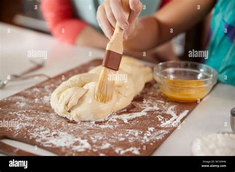 Jewish Girl Glazing Plaited Challah Dough With Mum Close Up Stock