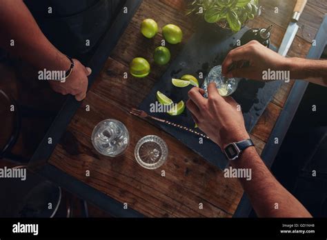 Top View To Two Bartenders Preparing Cocktail Experimenting With New