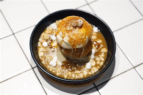 Cronut 반죽 또는 크로 도넛 마 시 멜로 바 삭 바 삭 마 카 다 미아 및 짠 카라멜 바닐라 아이스크림의 국자를 가진