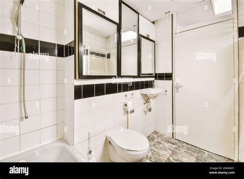 A Bathroom With Black And White Tiles On The Walls Toilet Sink