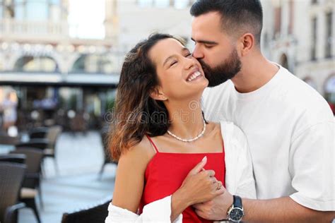 Handsome Young Man Kissing His Beautiful Girlfriend On City Street
