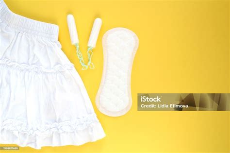 흰 치마 여자 생리대 탐폰 면봉이 노란색 바탕에 있다 여성 생리주기 기간 위생 개념입니다 린넨 및 건강 보호 아이디어 복사 공간