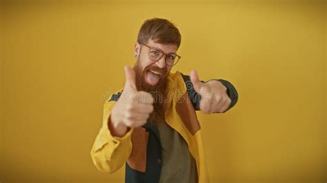 A Happy Man With A Beard And Glasses Giving Thumbs Up Against A Yellow