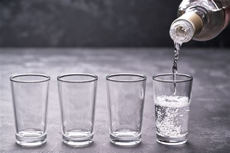 병에서 보드카를 검은 배경의 유리에 붓고 선택적으로 초점을 맞 춥니 다 0명에 대한 스톡 사진 및 기타 이미지 0명 건강