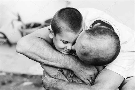 un tío gentilmente abraza y besa a su pequeño sobrino en la mejilla en
