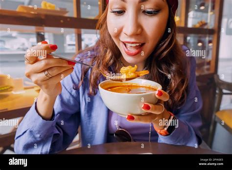Happy Girl Eating Spicy Thai Soup Tom Yam In Authentic Restaurant Stock