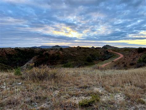 Sunset Over Native Grassland And Badlands In North Dakota R
