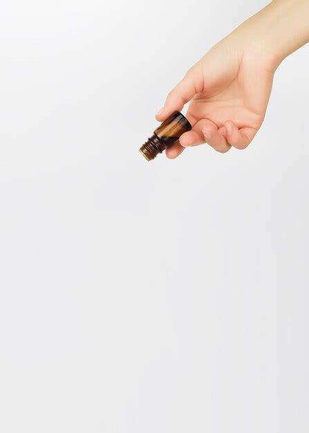 Premium Photo Female Hand Pours Essential Aromatic Oil From A Small Glass Bottle