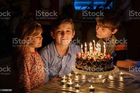 생일을 축하하는 십 대 초반 소년을 축하합니다 미취학 자매 아이와 두 아이 소년 형제가 케이크에 촛불을 함께 불고 있습니다 세 자녀 형제 자매와 함께 행복 하 고 건강 한
