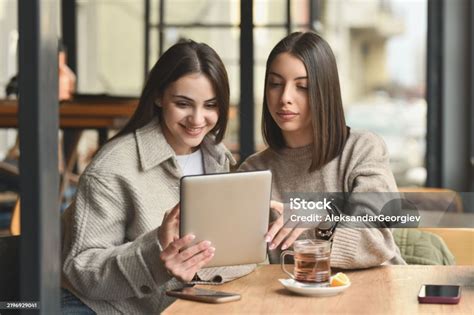 카페에서 소셜 미디어를 탐색하는 동안 태블릿 화면에서 미소 짓는 두 명의 여자 친구 2명에 대한 스톡 사진 및 기타 이미지 2명 검색 긍정적인 감정 표현 Istock