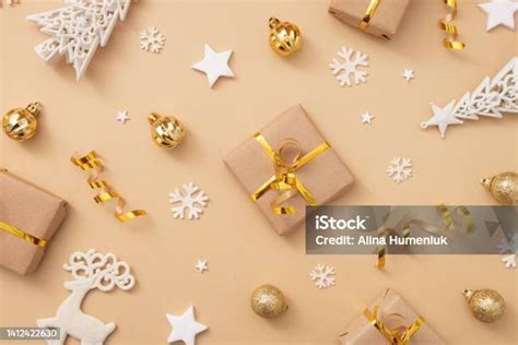 파스텔 베이지 색 배경에 황금 리본과 크리스마스 장식으로 크래프트 종이로 싸인 선물 상자 휴일 선물 개념 위쪽 보기 0명에 대한 스톡 사진 및 기타 이미지 Istock