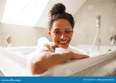The Woman Is Happily Bathing In A Jacuzzi Tub Smiling With Joy Stock