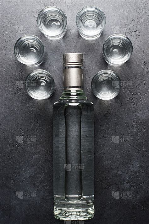 深色背景上放着一瓶伏特加和六玻璃杯。平躺