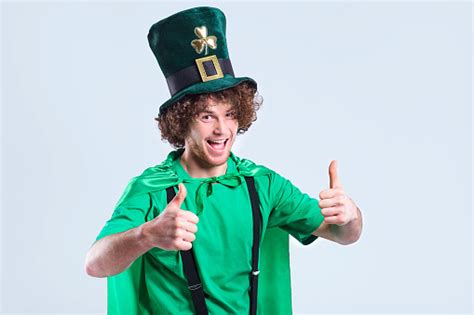곱슬 머리 젊은이 성 패 트 릭의 소송에서 그의 손가락을 보여줍니다 St Patricks Day에 대한 스톡 사진 및 기타