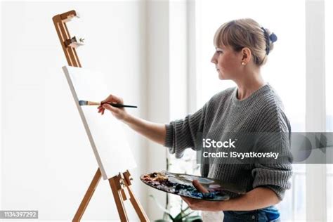 스튜디오에서이 젤에 예술가 회화 소녀는 브러시로 풍경을 페인트 합니다 측면에서 본 여성 화가 그림 그리기에 대한 스톡 사진 및 기타 이미지 Istock