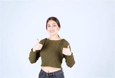 흰색 바탕에 엄지 손가락을 포기하는 예쁜 젊은 여자 무료 사진