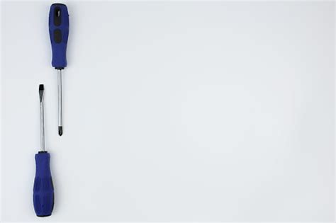 파란색 손잡이가 있는 두 개의 스크루 드라이버가 텍스트를 위한 공간이 있는 측면의 흰색 배경에 서로 마주 보고 있습니다 수리 비틀림의 개념 0명에 대한 스톡 사진 및 기타