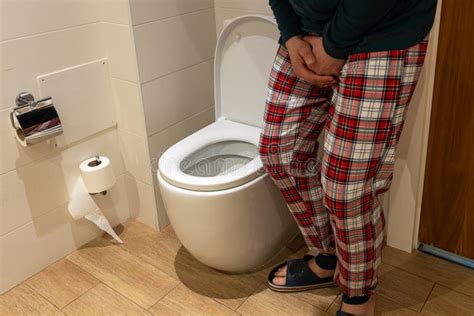 A Man In Pajamas Holds His Crotch By The Toilet Urinating Problem