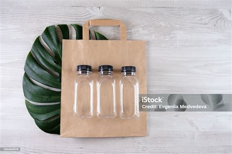 갈색 종이 에코 백에 3 개의 플라스틱 병 로고를 위한 장소 복사 공간이 있는 회색 배경에 친환경 식품 포장 및 면 에코 백 케이터링 및 길거리 패스트푸드용 용기 가방에