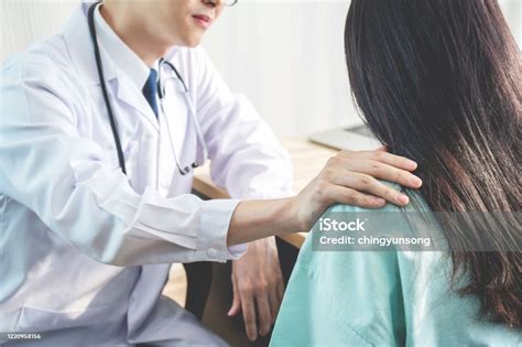 친절한 남성 의사는 여성 환자를 위로하고 리셉션 동안 사무실에서 휴식을 취할 수 있도록 어깨에 손을 사용 상담 및 건강 관리의