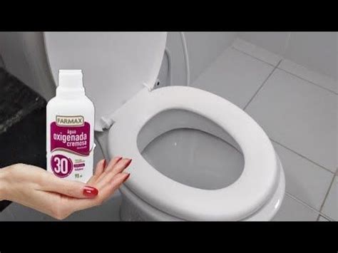 A Woman Holding A Bottle Of Deodorant Next To A Toilet