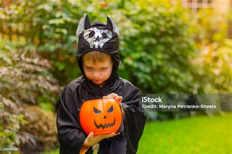 마당에서 할로윈 과자를 위해 잭 오 랜턴 얼굴이있는 양동이 호박을 들고있는 박쥐 해골 의상을 입은 어린이 소년 10월에 대한 스톡 사진 및 기타 이미지 Istock