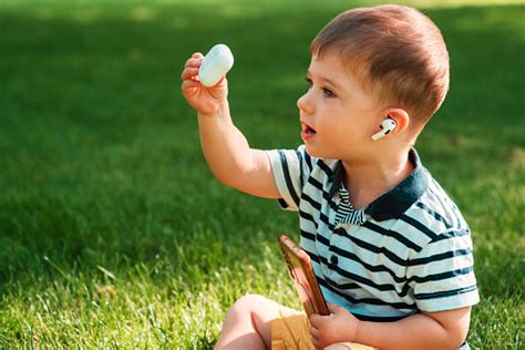 귀여운 유럽인 소년이 전경에서 무선 헤드폰 상자를 들고 있습니다 무선 헤드폰 착용 귀여운에 대한 스톡 사진 및 기타 이미지 귀여운 남성 놀이 Istock