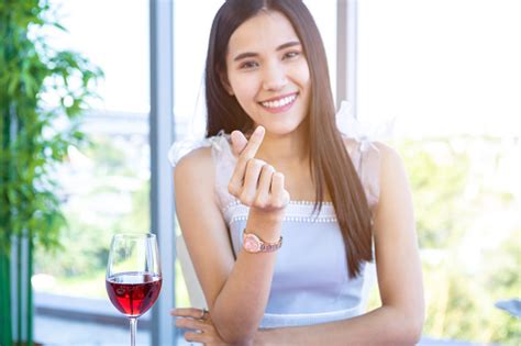 발렌타인 데이 컨셉 와인 잔과 레스토랑 배경에 빨간색과 분홍색 장미 꽃다발테이블 음식에 앉아 행복한 아시아 젊은 여성의 하트 모양 또는 미니 심장 수제 개념에 대한 스톡